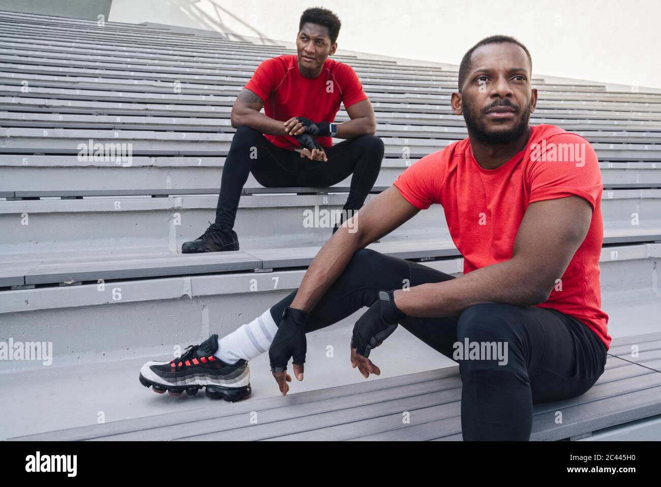 Two sportsmen sitting on stairs in a stadium Stock Photo - Alamy