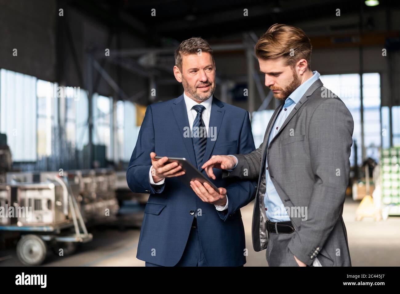 Two businessmen with tablet having a meeting in a factory Stock Photo ...