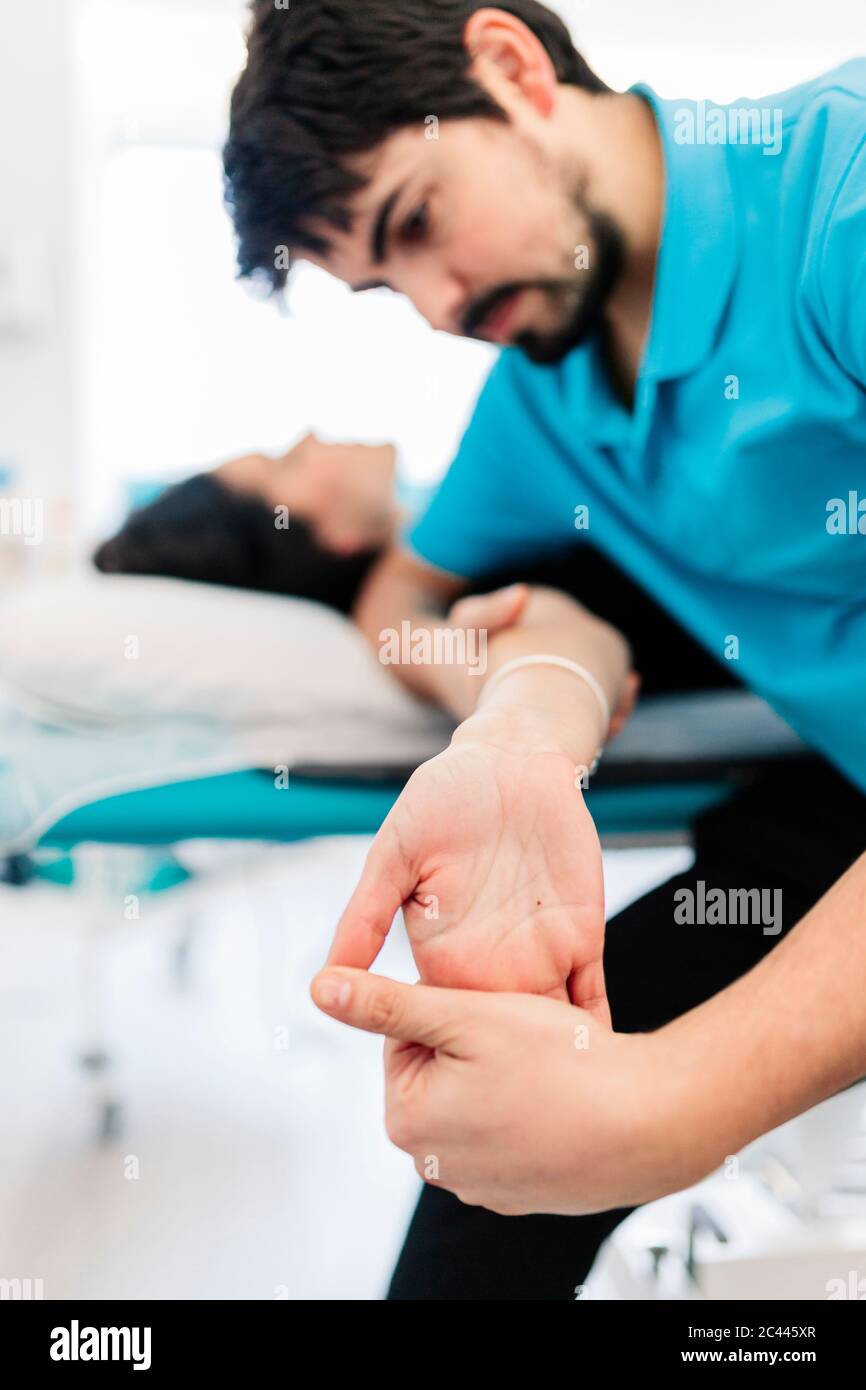 Visually impaired male therapist treating woman's hand in clinic Stock ...