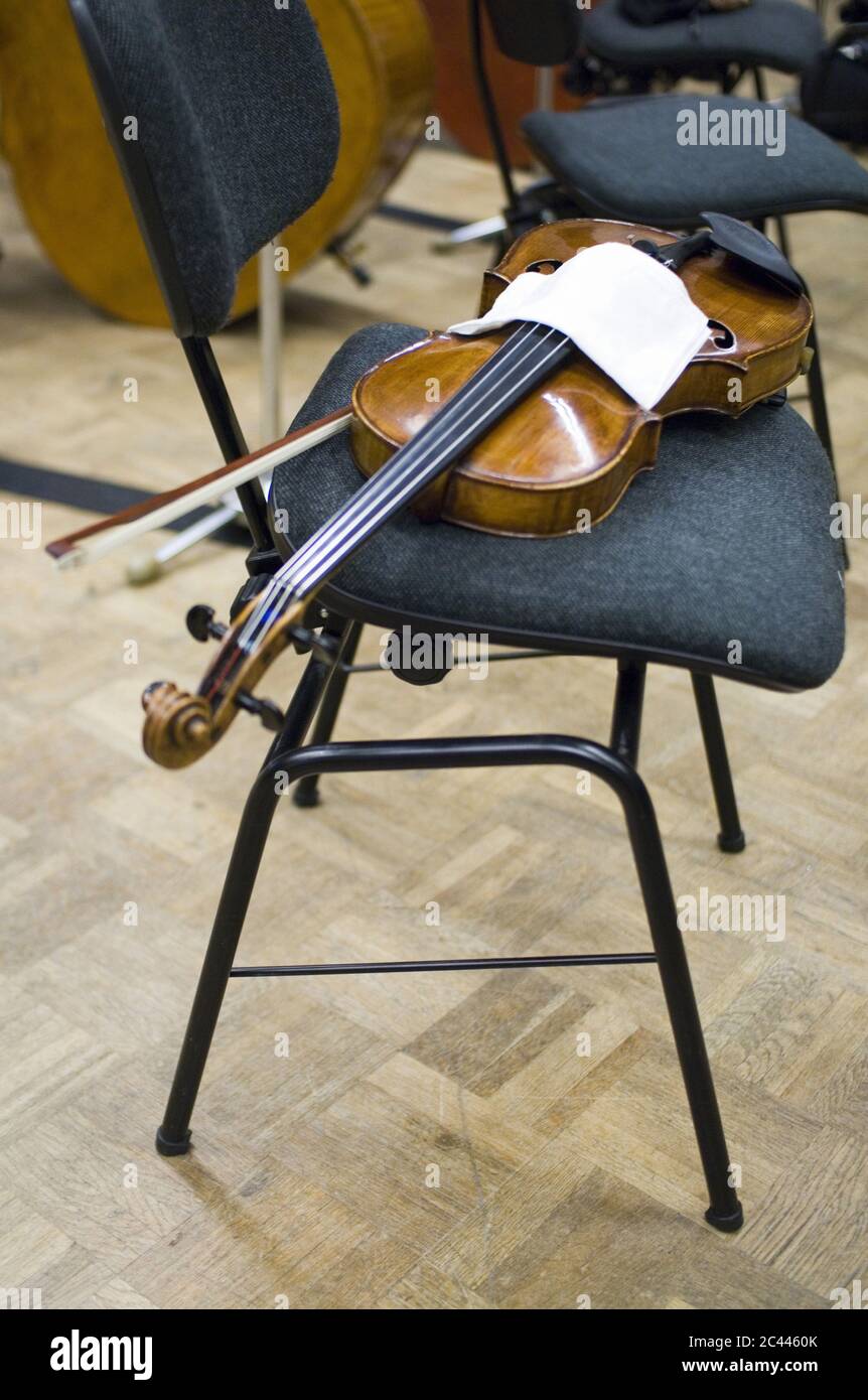 Violin lies on a chair Stock Photo - Alamy