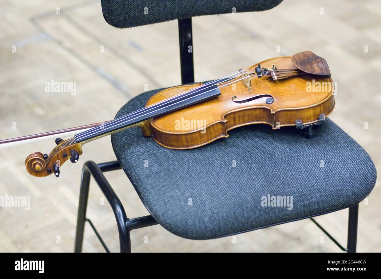 Violin lies on a chair Stock Photo - Alamy