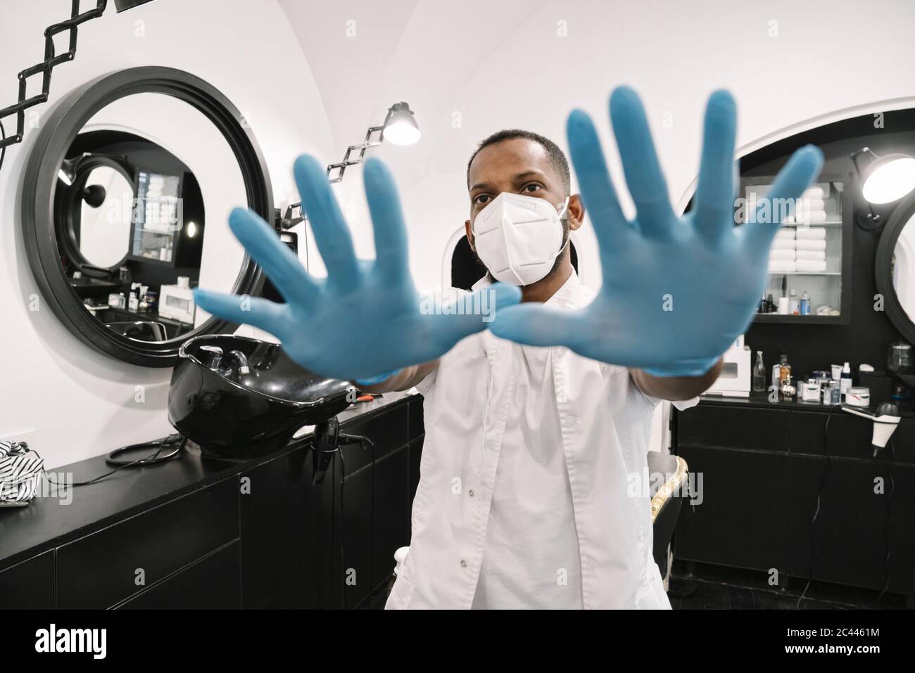 Barber wearing surgical mask and reusable gloves Stock Photo - Alamy