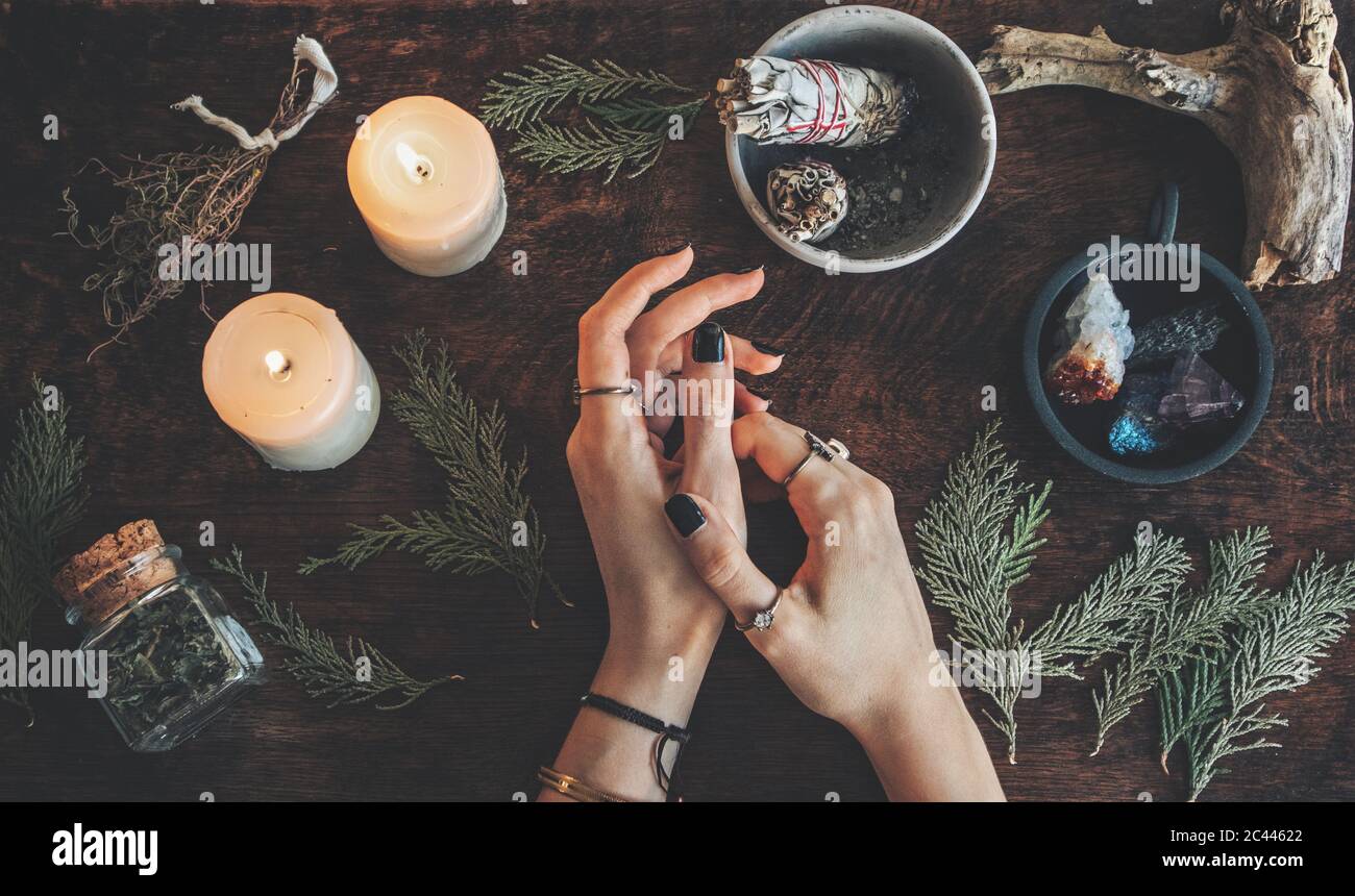 Witches hands on table ready for spell work. Wiccan witch altar filled ...