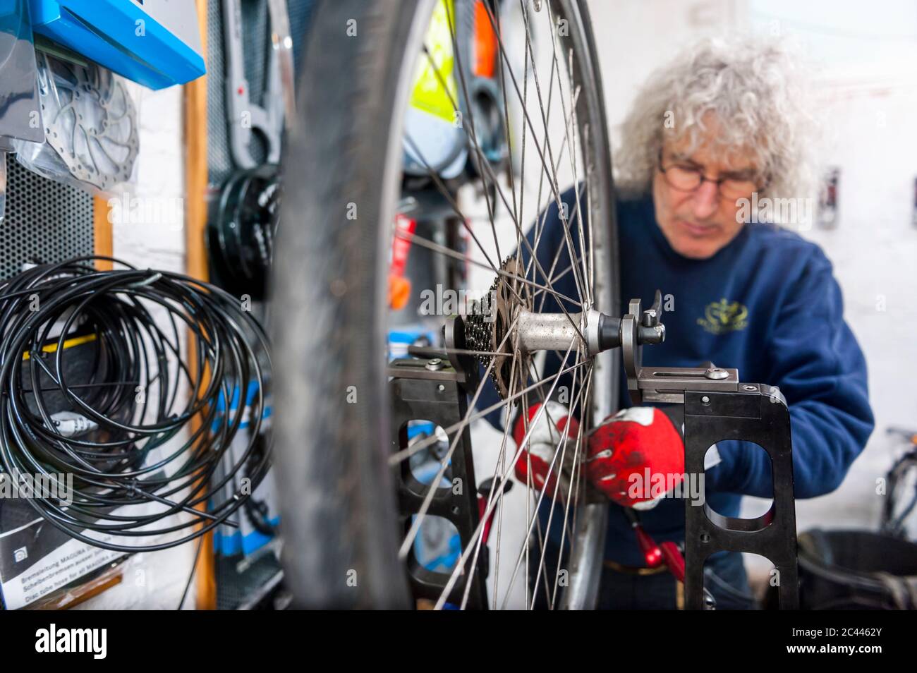 Bicycle mechanic working in bike shop Stock Photo - Alamy