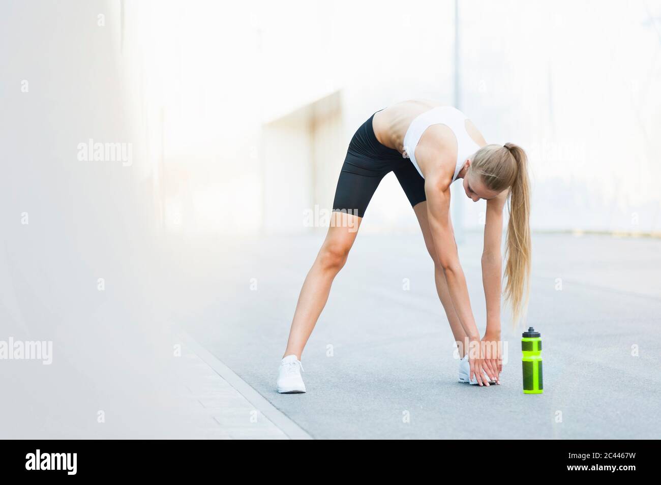 Female jogger stretching her legs in the city Stock Photo - Alamy