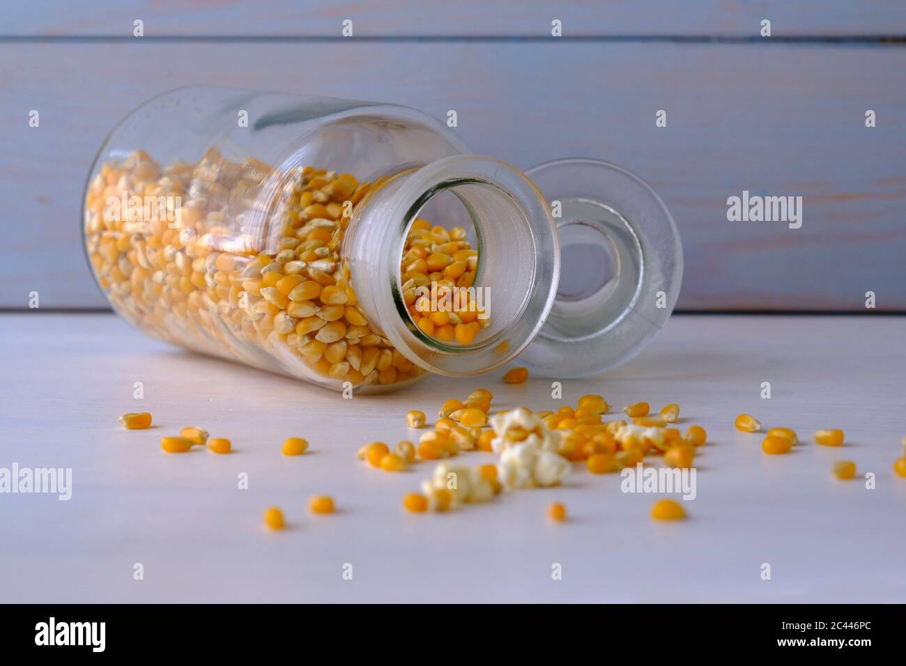 Corn kernels spilling out from glass jar lying on ground Stock Photo ...
