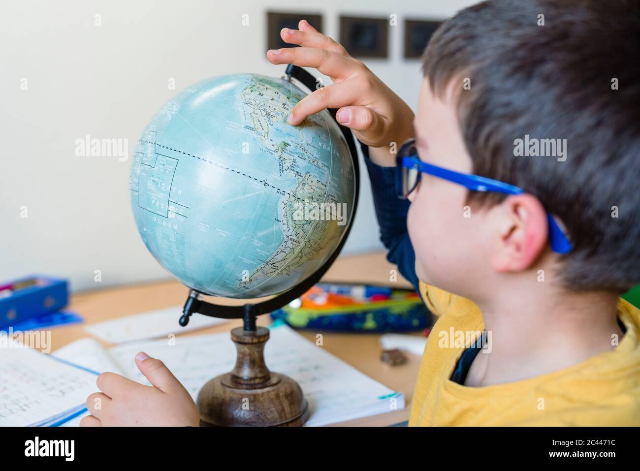 Student exploring on globe during homeschooling Stock Photo - Alamy