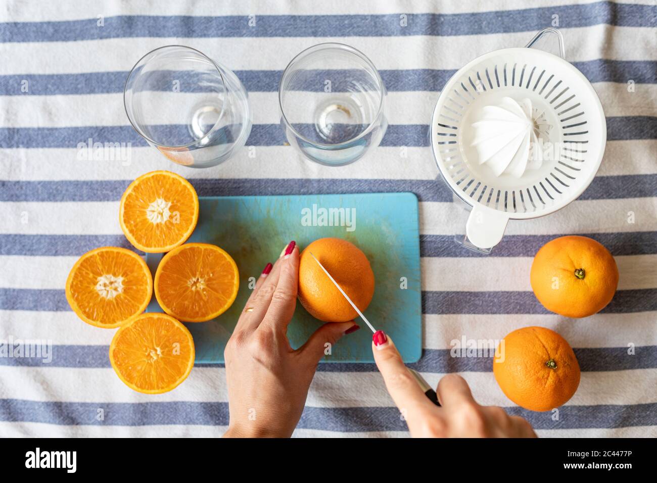 Woman slicing fresh oranges for freshly squeezed orange juice Stock ...
