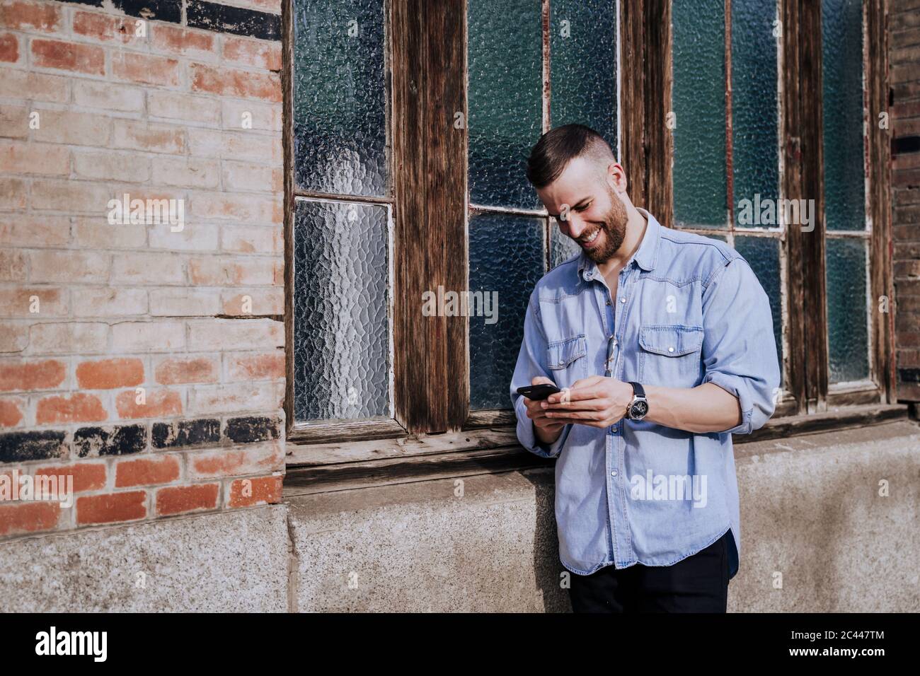 Man reading phone smiling hi-res stock photography and images - Alamy