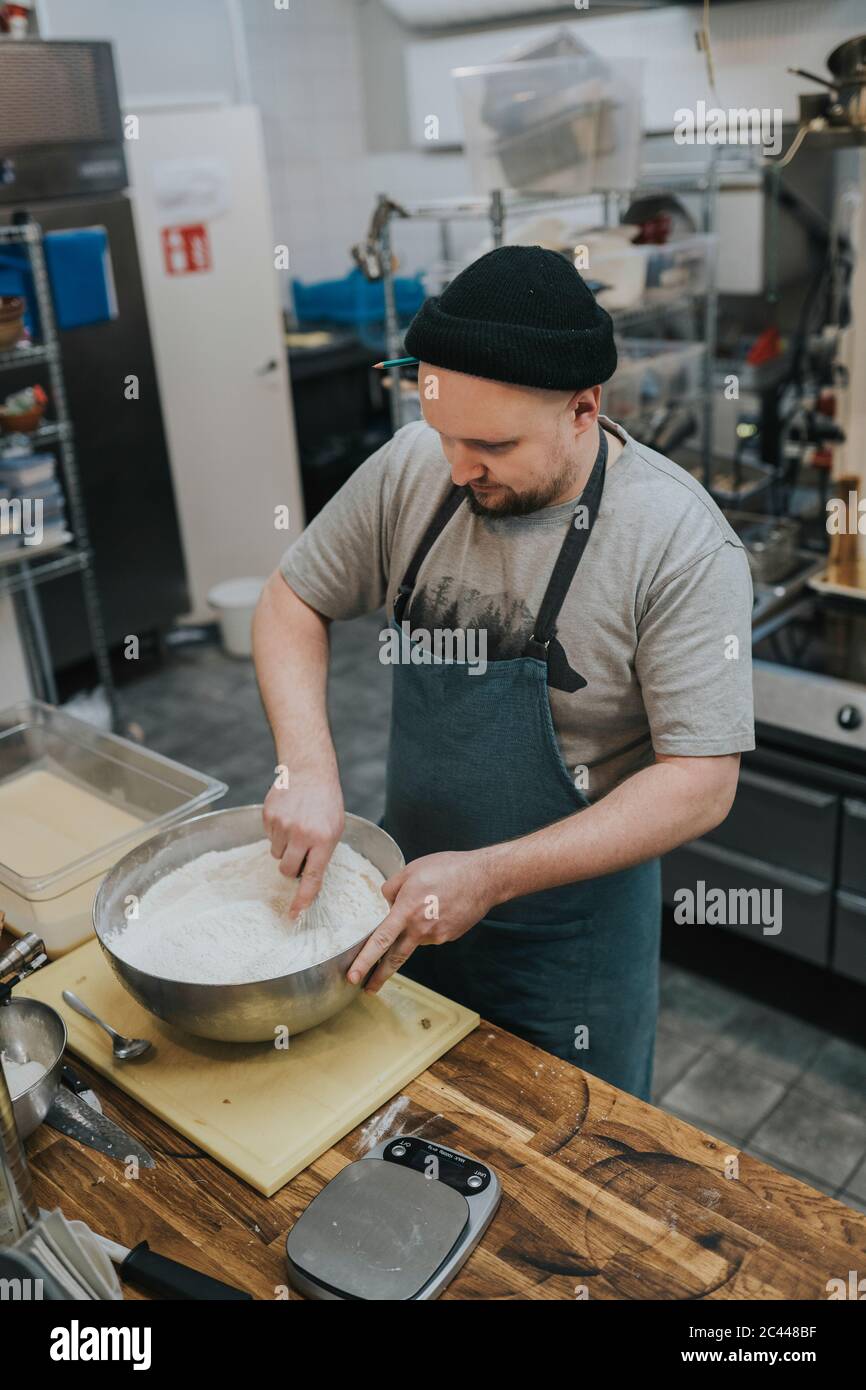 Male chef mixing flour in bowl at commercial kitchen counter Stock ...