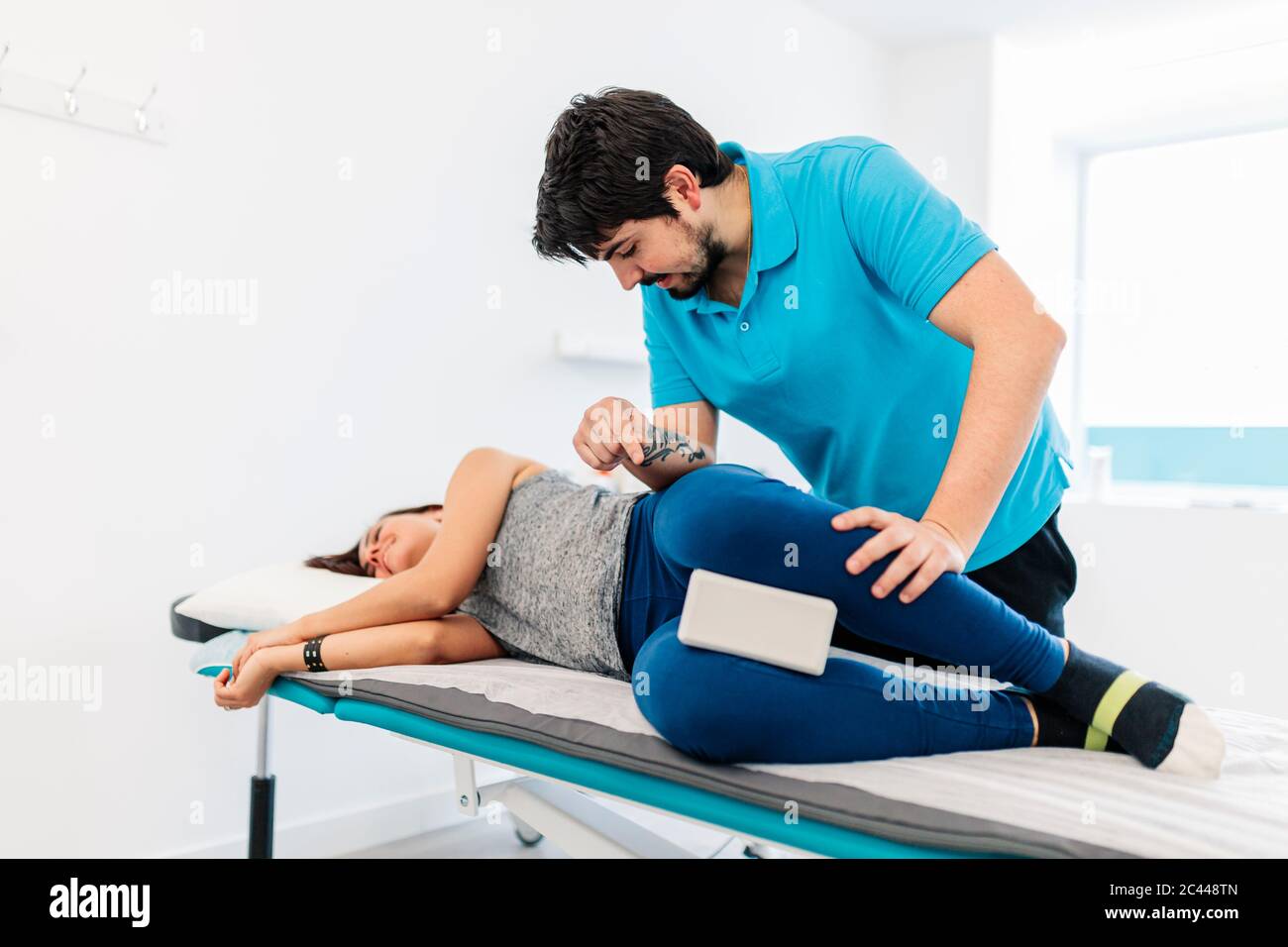 Visually impaired therapist treating woman's leg in clinic Stock Photo ...