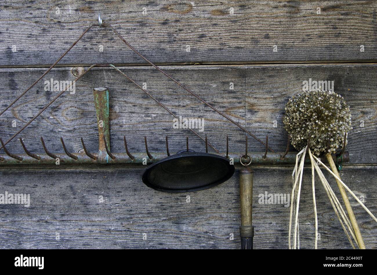 Wooden wall with rake Stock Photo - Alamy
