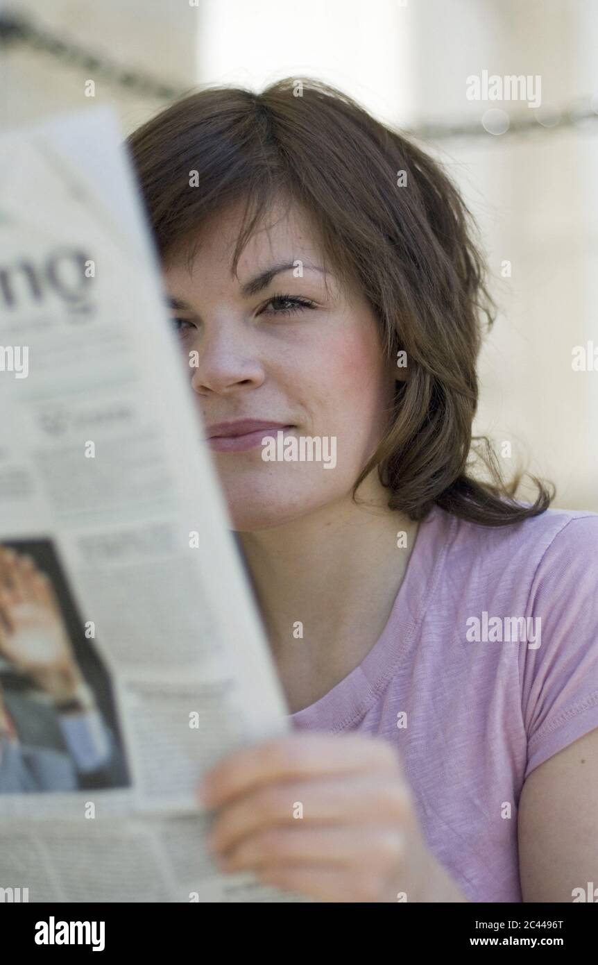 Young woman reads newspaper Stock Photo - Alamy