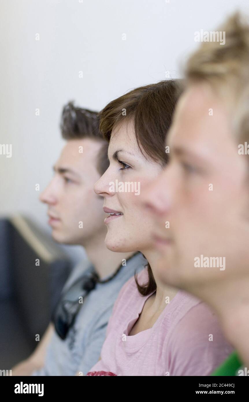 Three friends are sitting in a row Stock Photo - Alamy