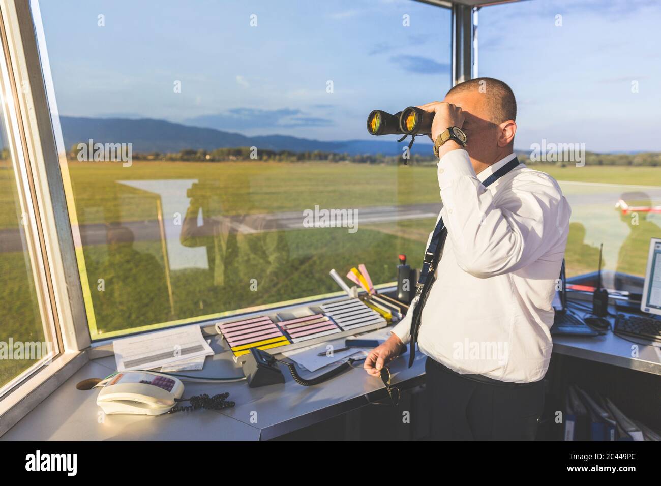 Pilot standing in control tower, using binoculars Stock Photo - Alamy