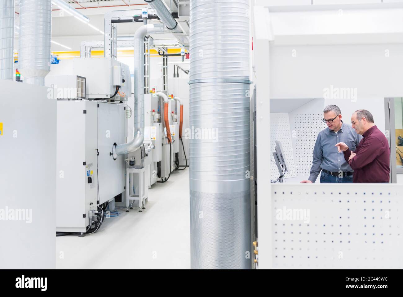 Two businessmen having a discussion in a factory Stock Photo - Alamy