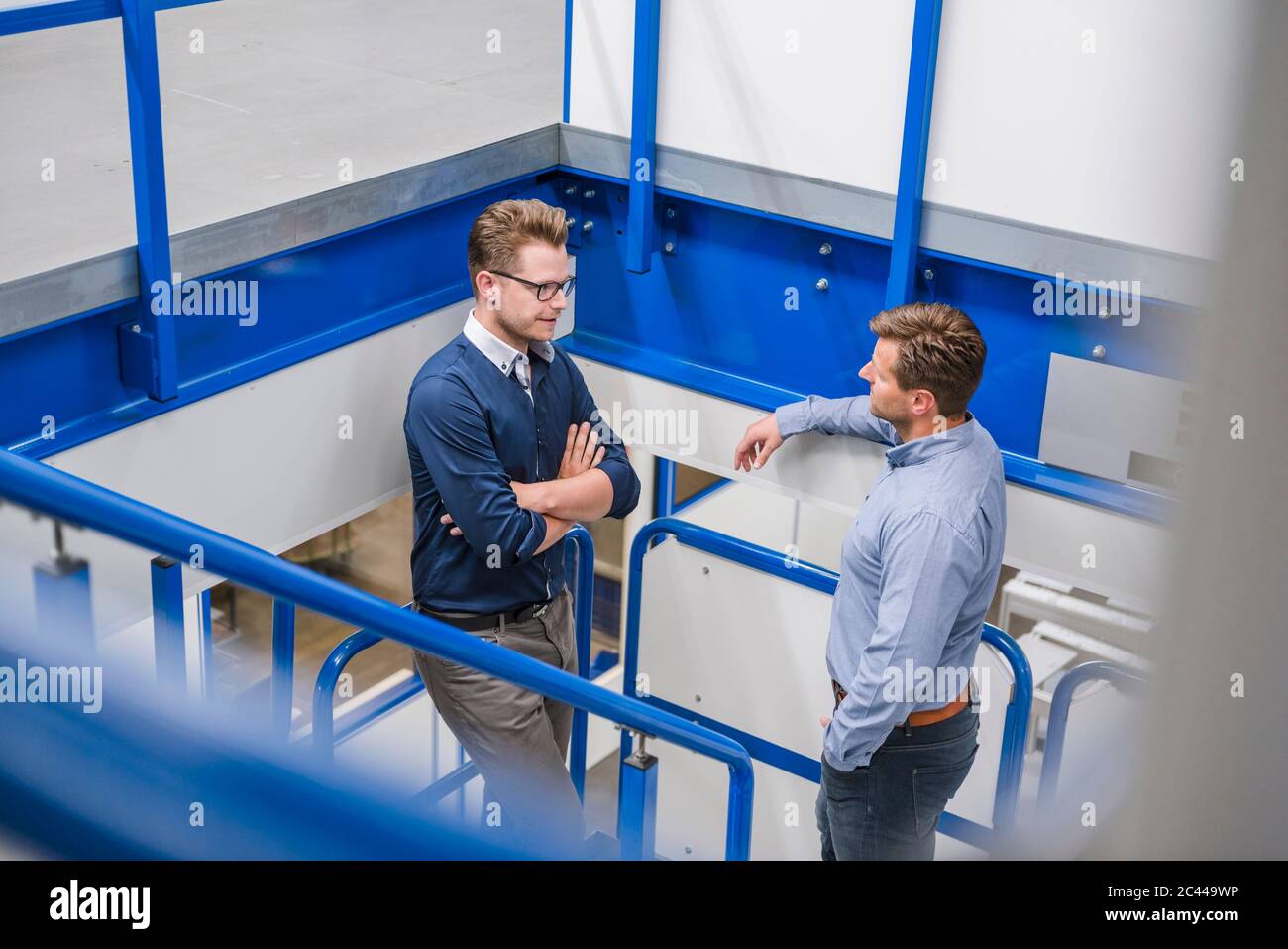 Two businessmen talking in factory Stock Photo - Alamy