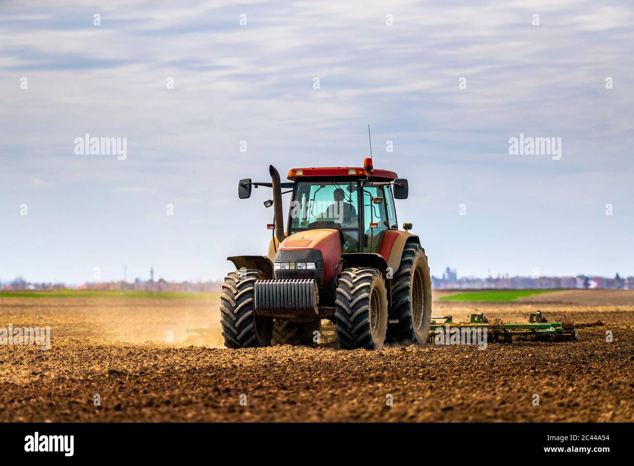 Farmer in tractor plowing field in spring Stock Photo - Alamy