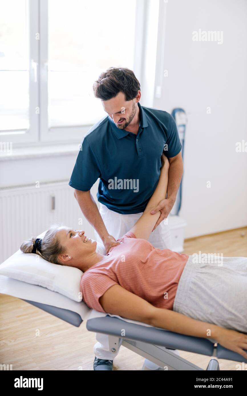 Physiotherapist giving treatment to female patient Stock Photo - Alamy