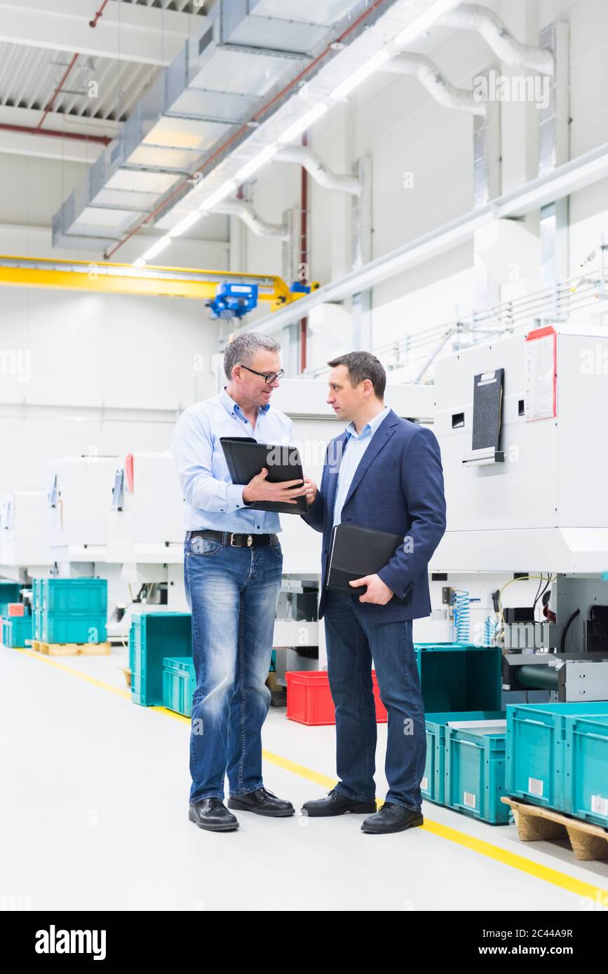 Two businessmen having a discussion in a factory Stock Photo - Alamy