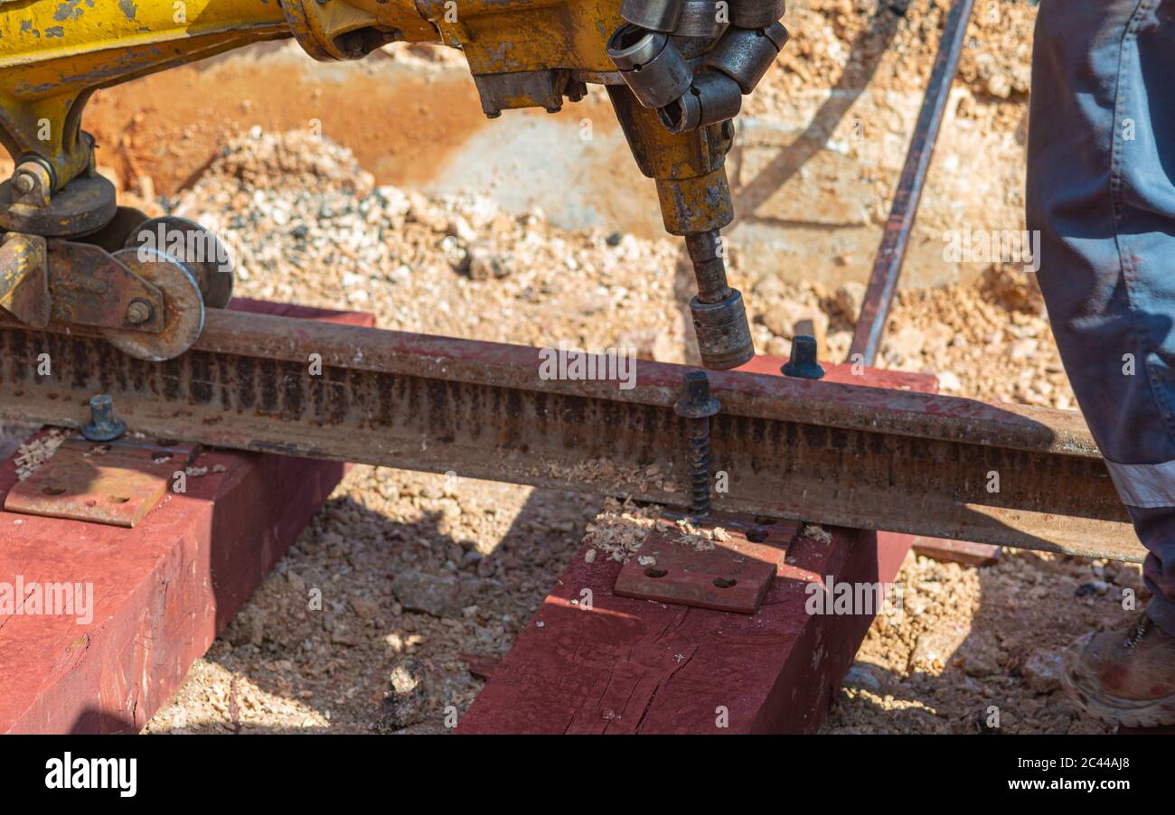 Railway workers bolting track rail. Detail worker with Light portable ...