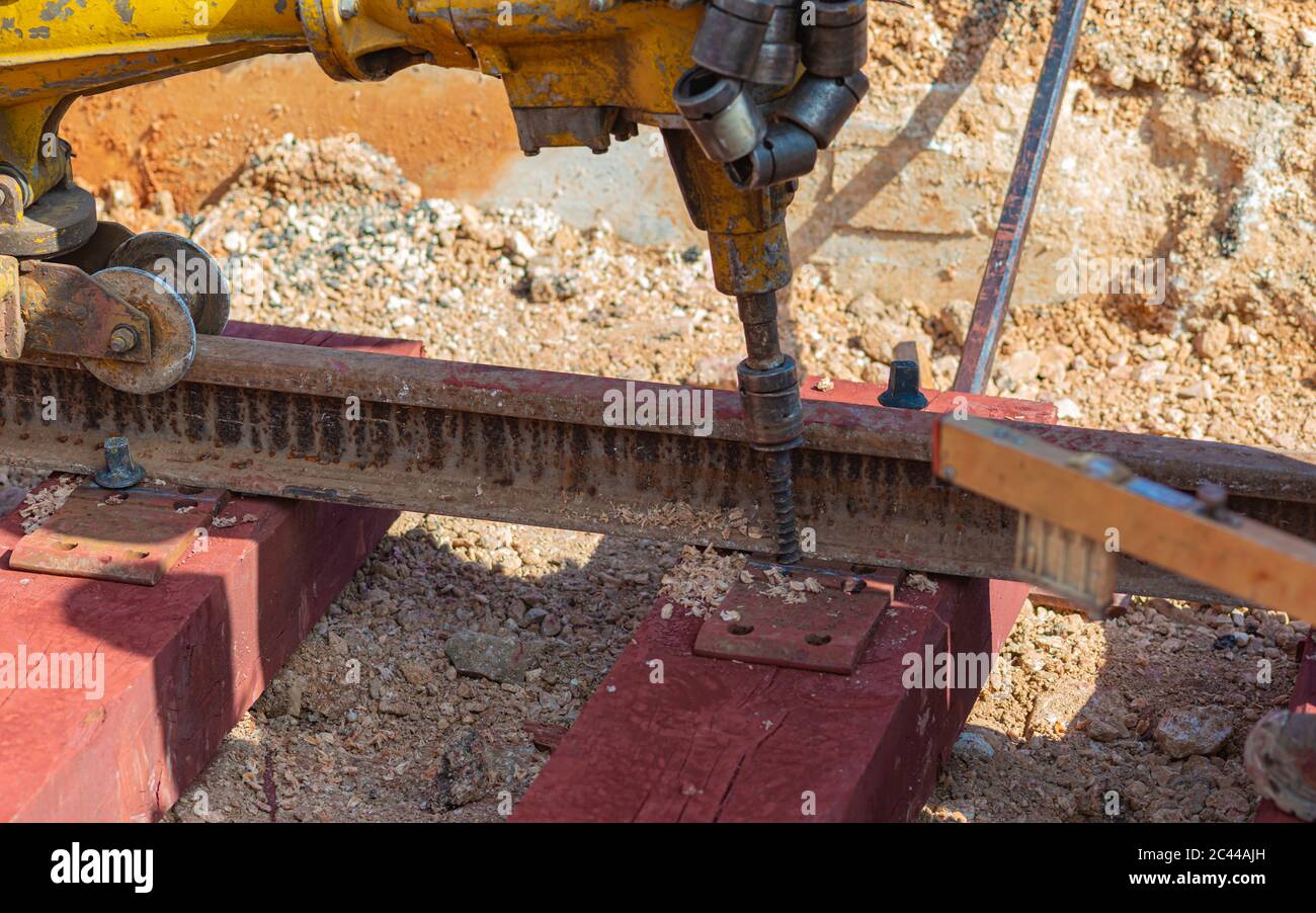 Railway workers bolting track rail. Detail worker with Light portable ...