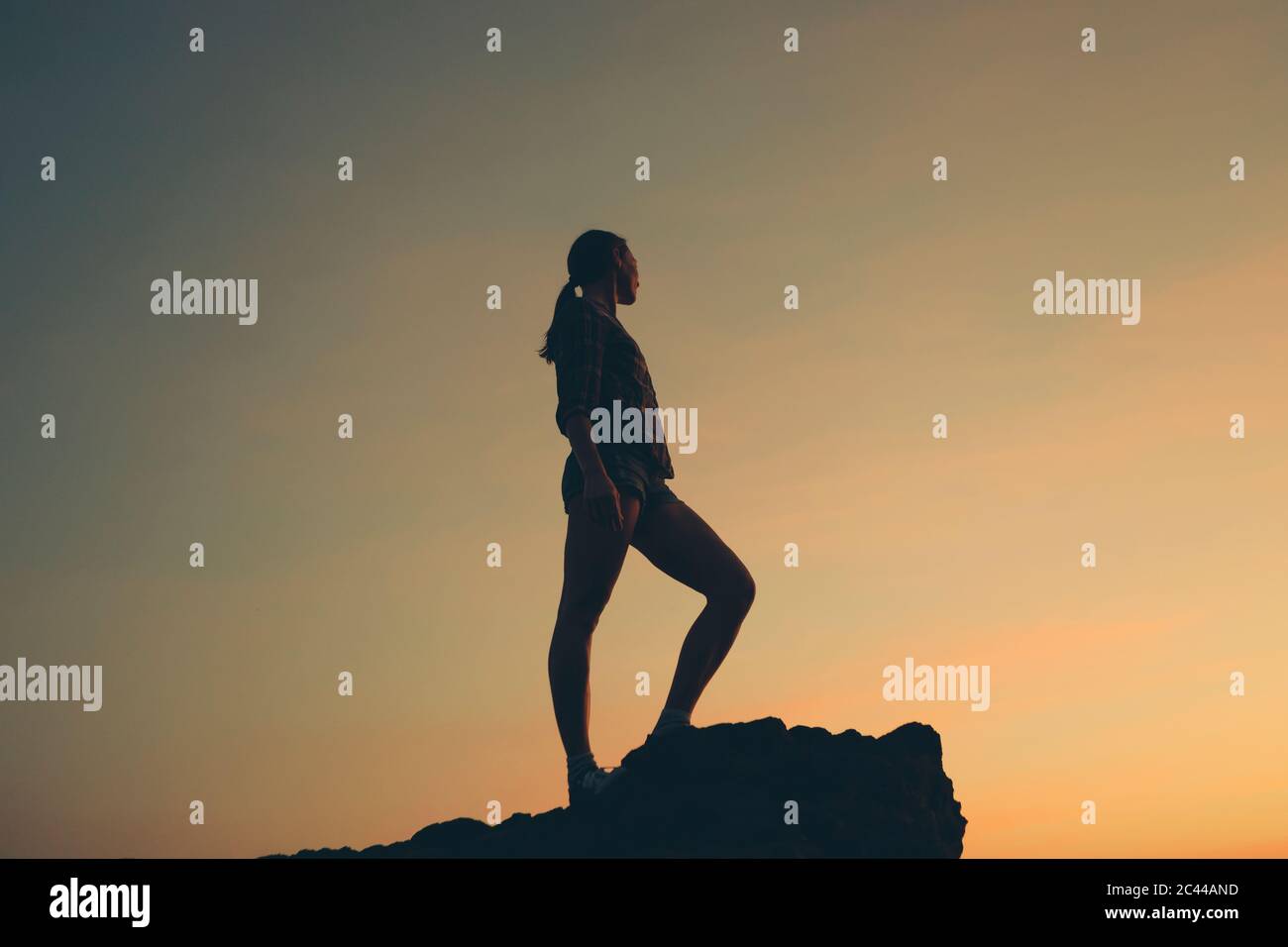 Woman standing on one leg at beach during sunset Stock Photo - Alamy