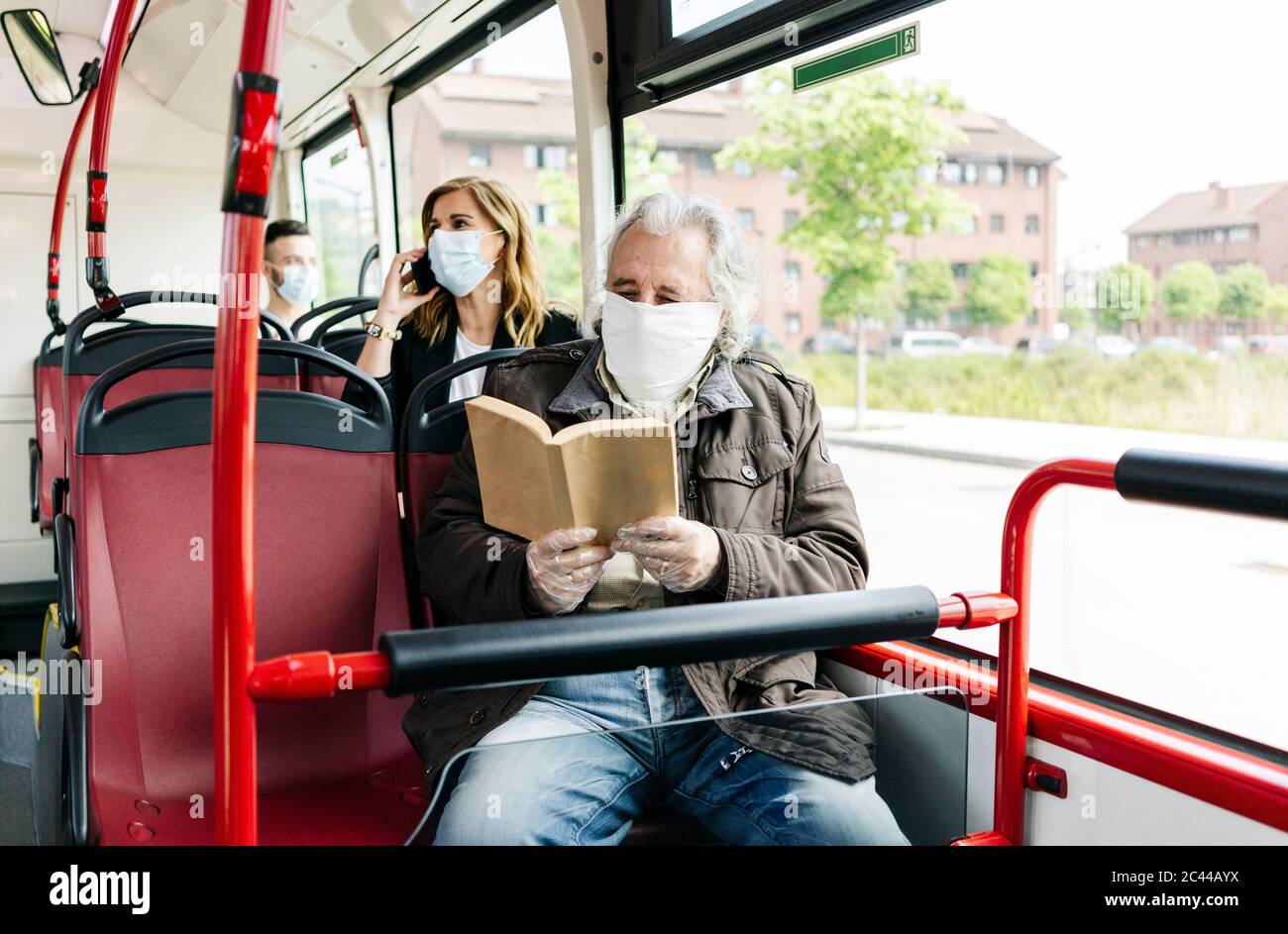 Senior man wearing protective mask public bus reading book hi-res stock ...