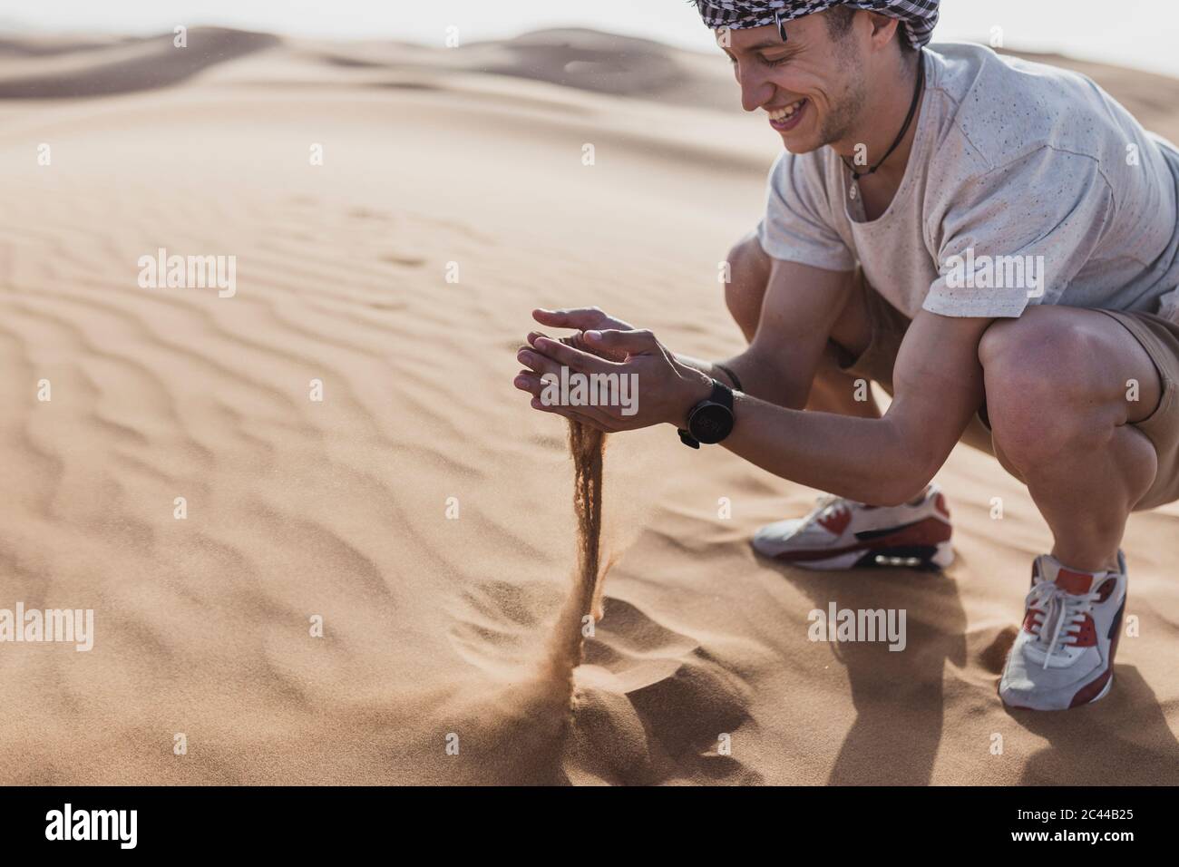 Happy male tourist playing sand desert dubai hi-res stock photography ...