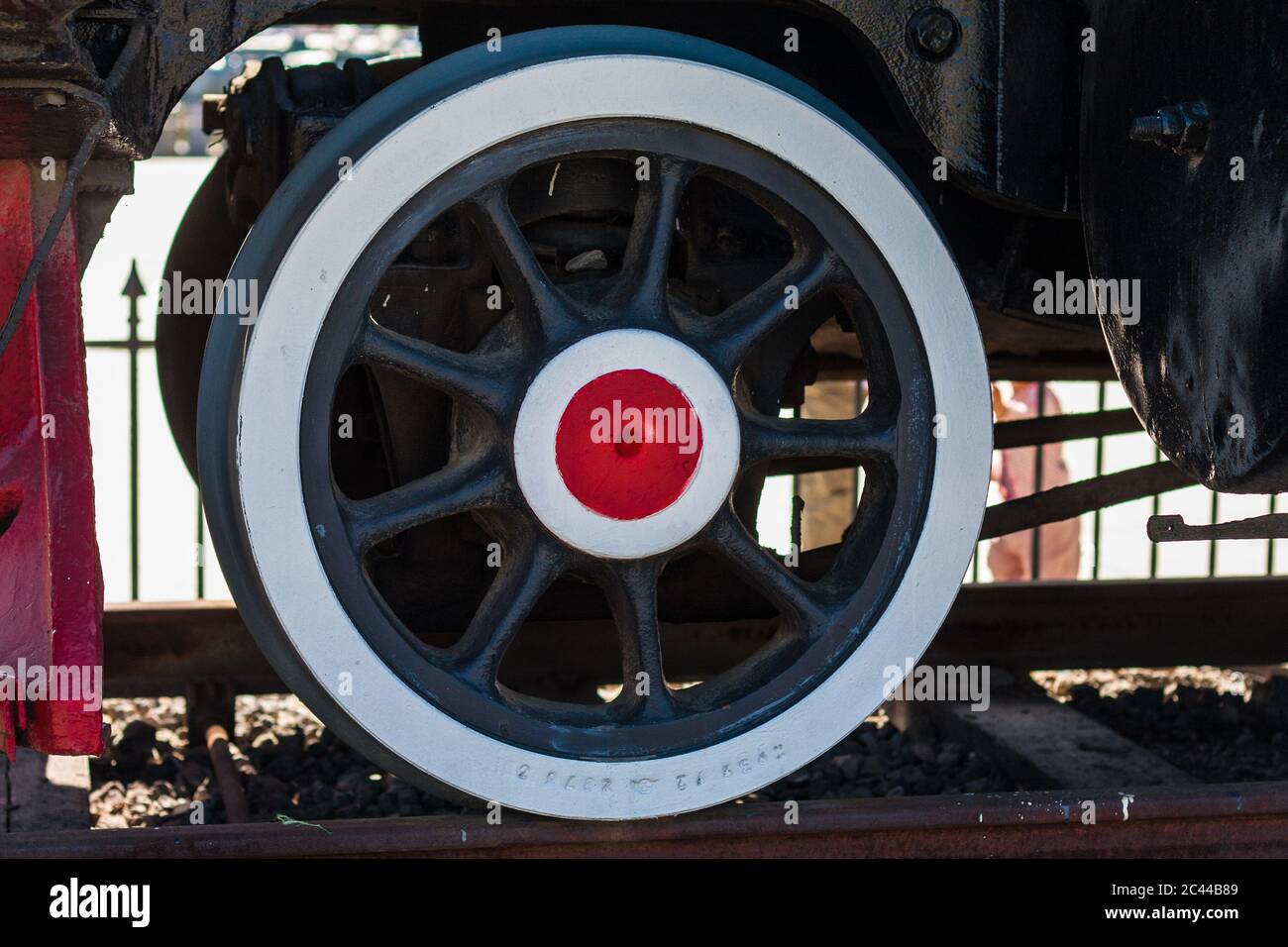Close-up of a driving wheel of an old-fashioned steamed red-black ...