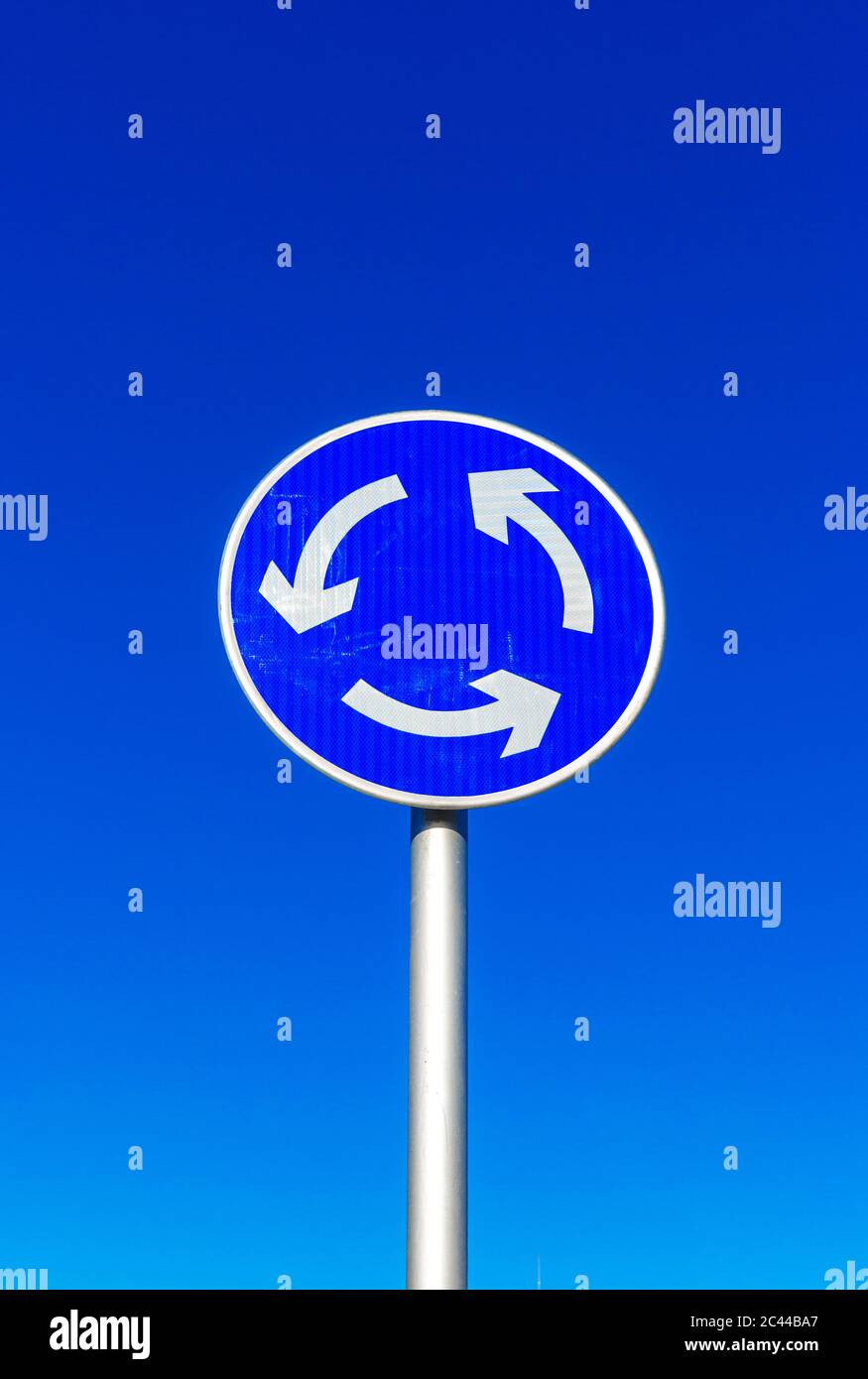 Blue sky with roundabout traffic symbol Stock Photo - Alamy
