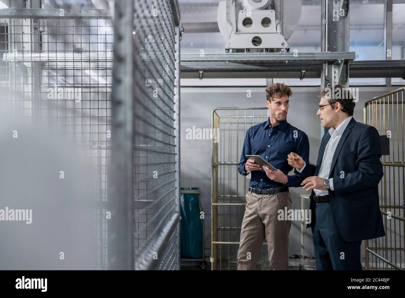 Two businessmen with tablet having a meeting in a factory Stock Photo ...