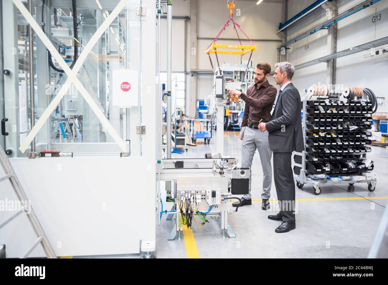 Two businessmen talking in a factory Stock Photo - Alamy