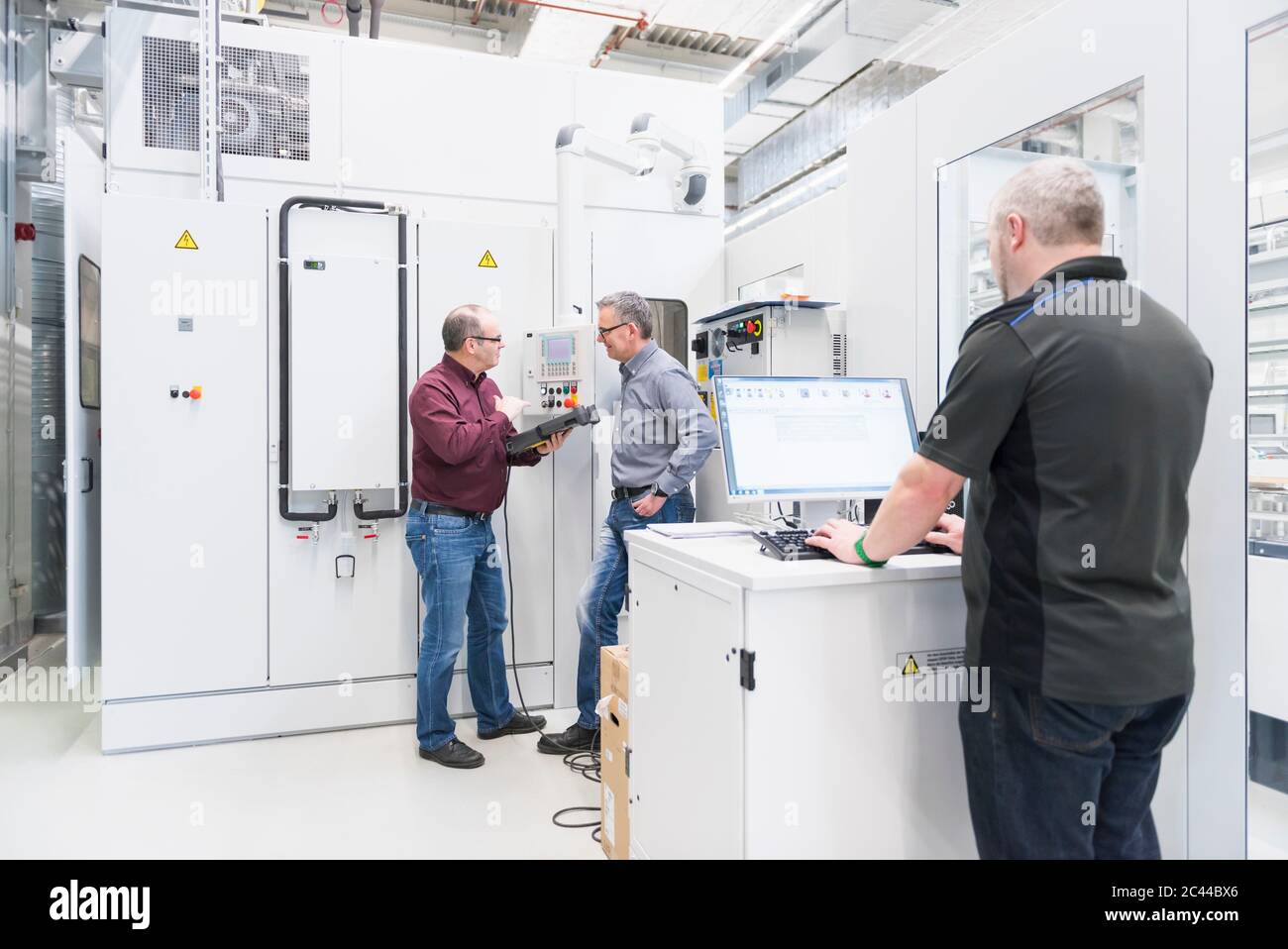 Two businessmen having a discussion in a factory Stock Photo - Alamy