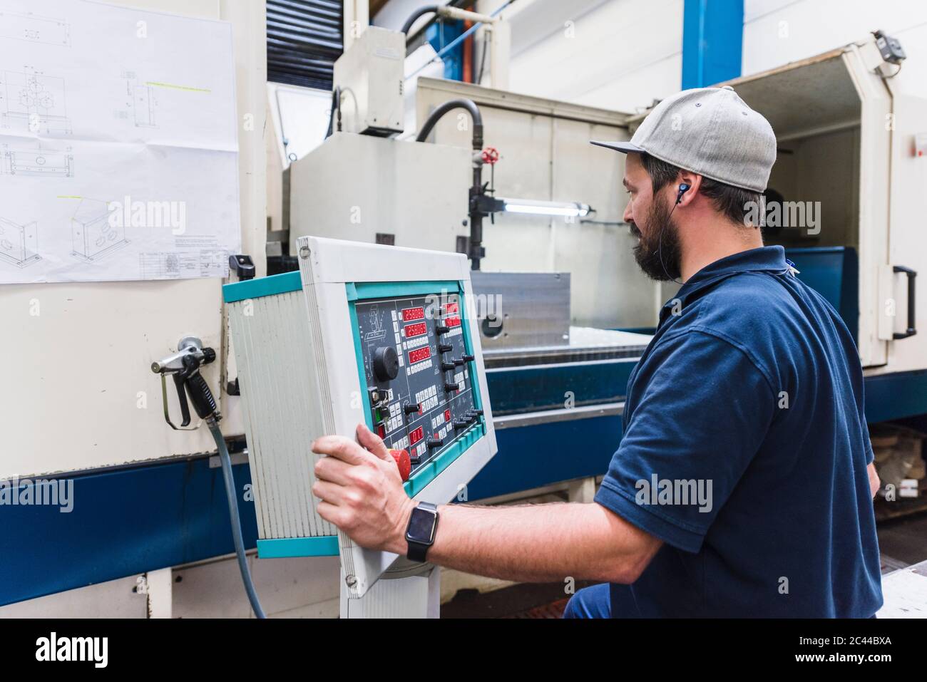 Man operating a machine in a factory Stock Photo - Alamy