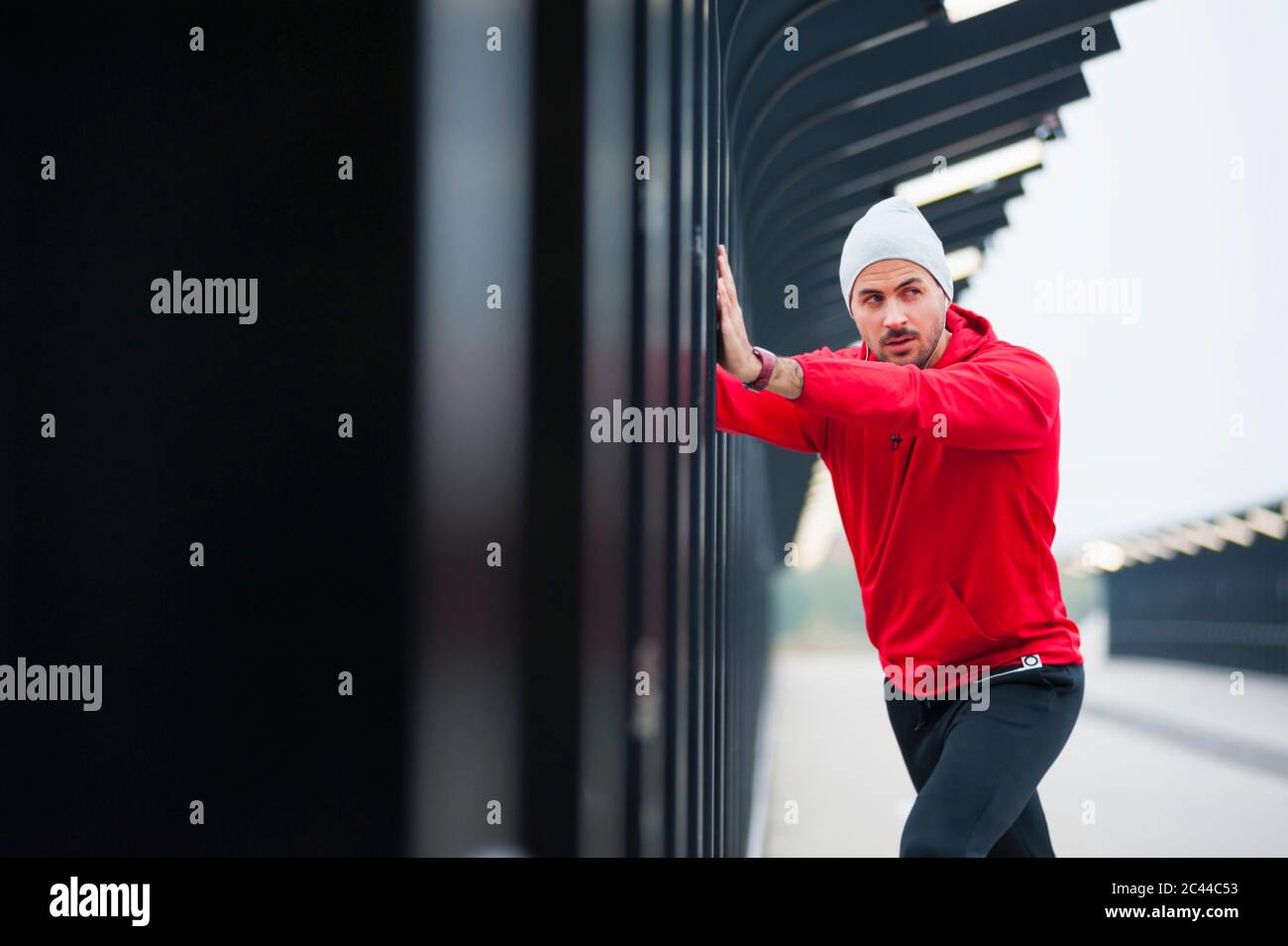Young man stretching on a bridge Stock Photo - Alamy