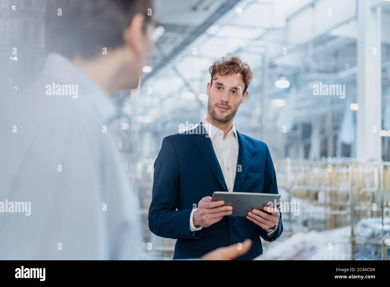 Two businessmen having meeting factory hall hi-res stock photography ...