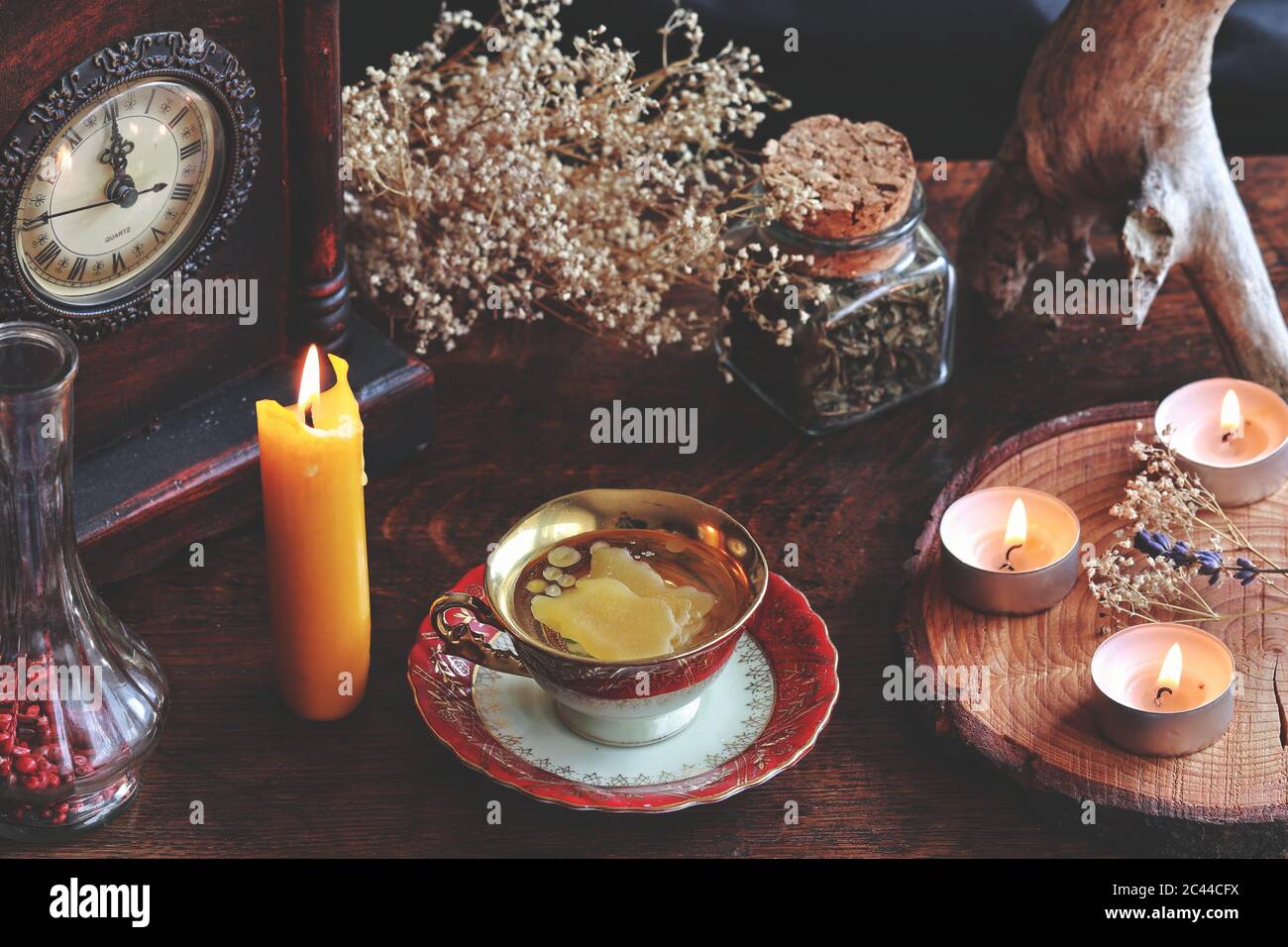 Candle wax poured into red gold vintage teacup as a divination form ...
