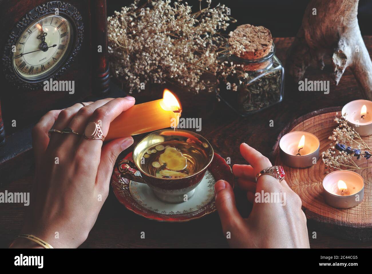 Female wiccan witch wearing vintage jewelry holding yellow candle and ...