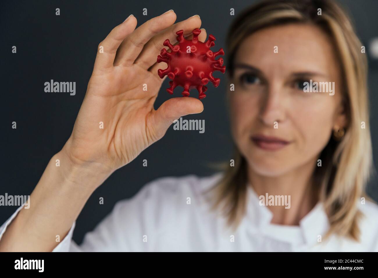 Female scientist looking at 3D model of SARS-CoV-2 virus Stock Photo ...