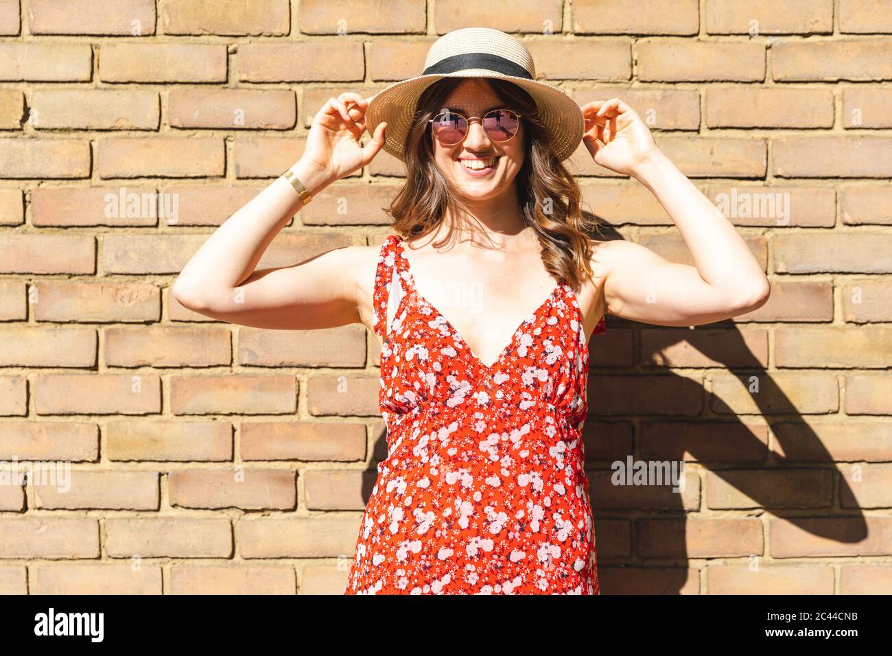 Happy young woman wearing a straw hat Stock Photo - Alamy
