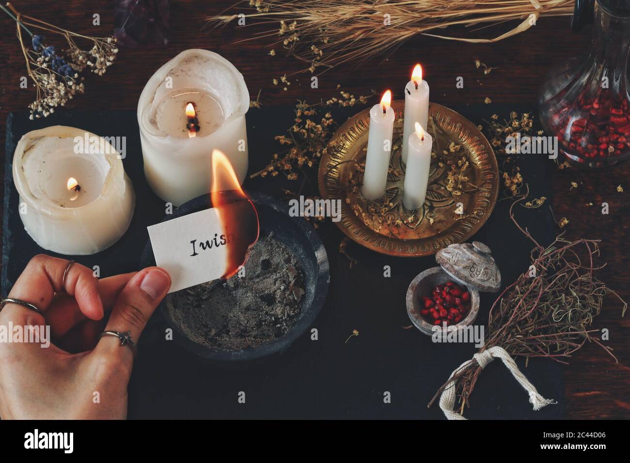Female wiccan witch holding a burning peace of paper in her hand. White ...