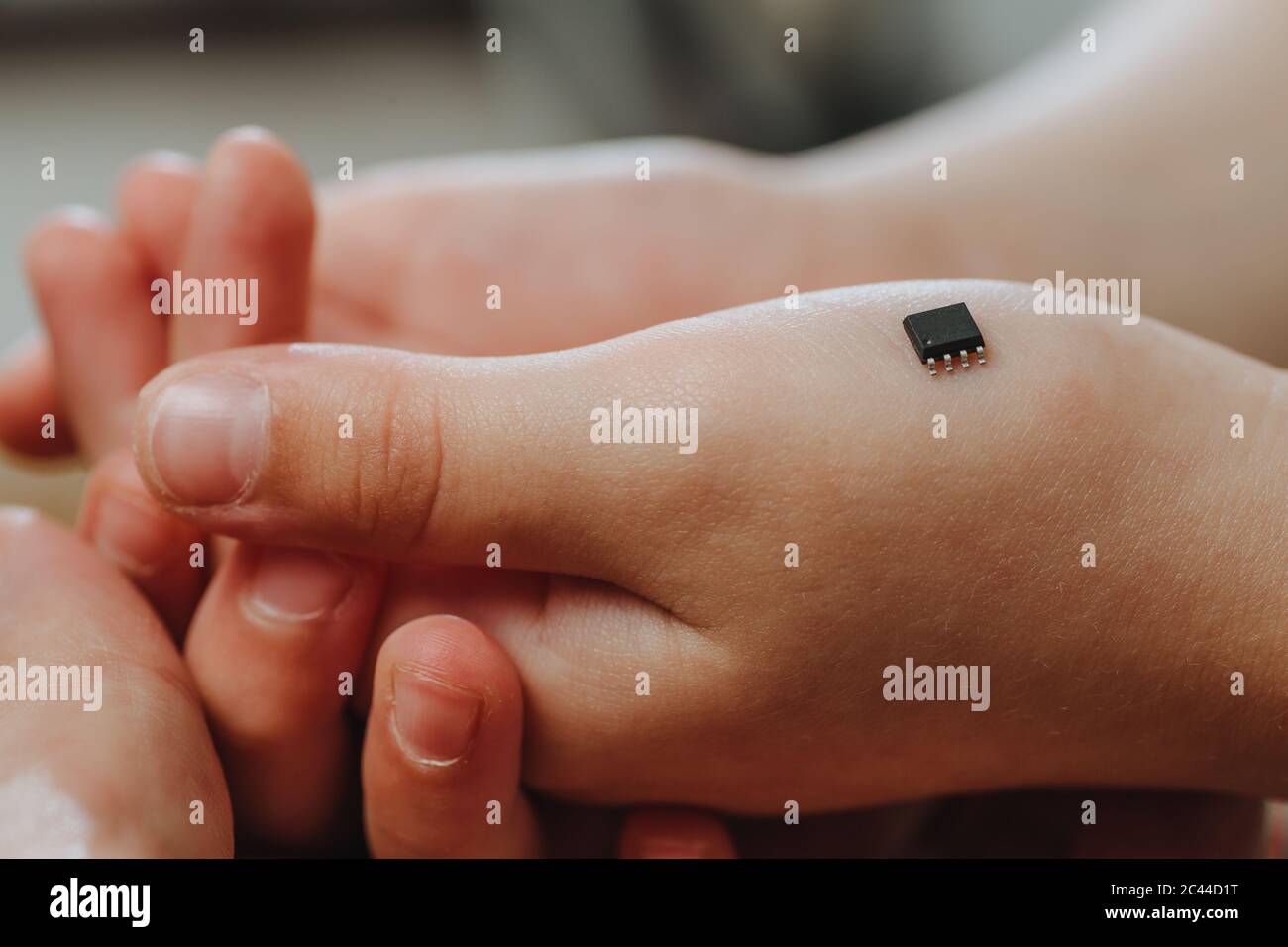 A small black chip lies on the palm of the hand of a child. Chipization ...