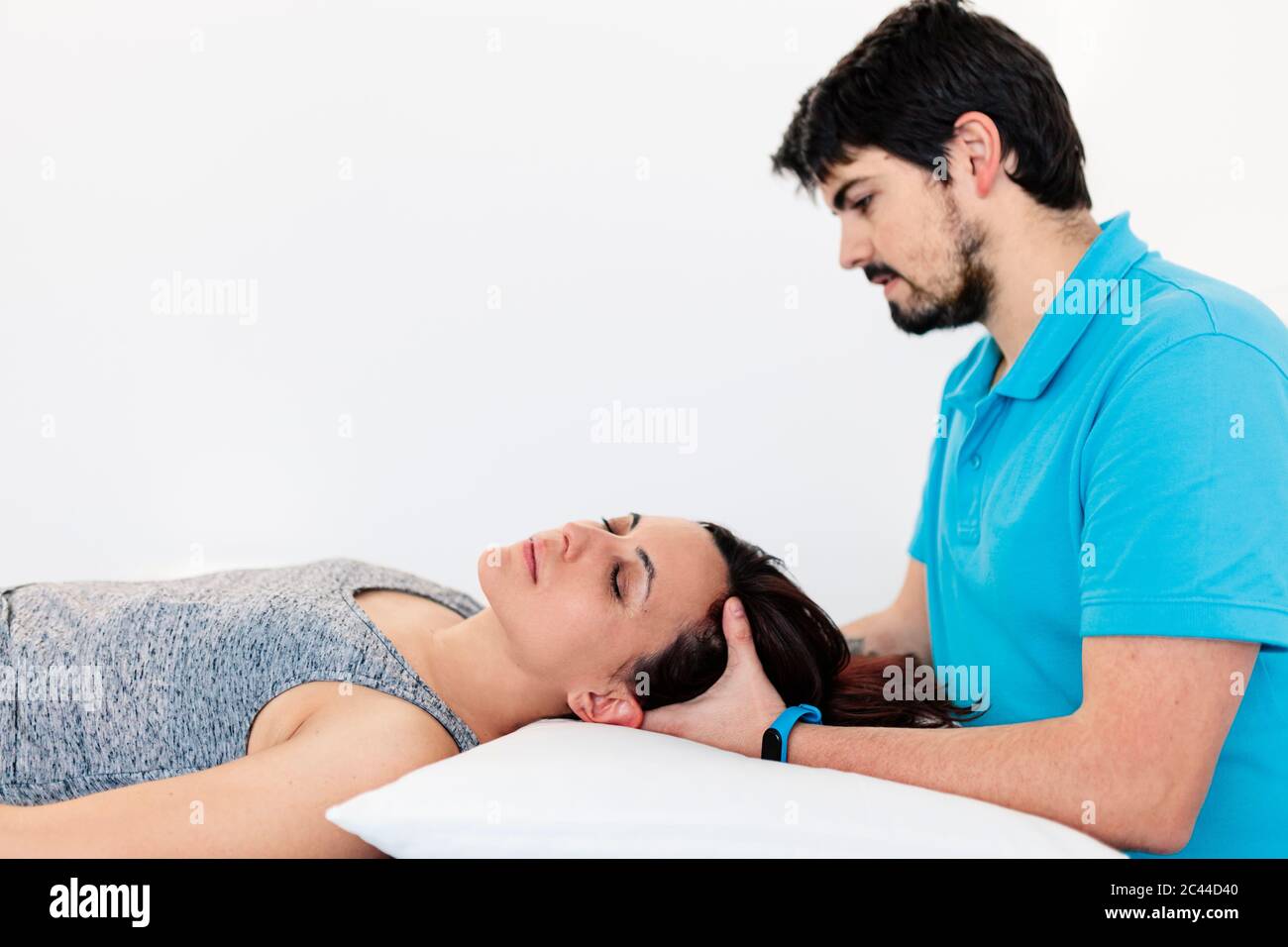 Visually impaired physical therapist massaging woman's head in clinic ...