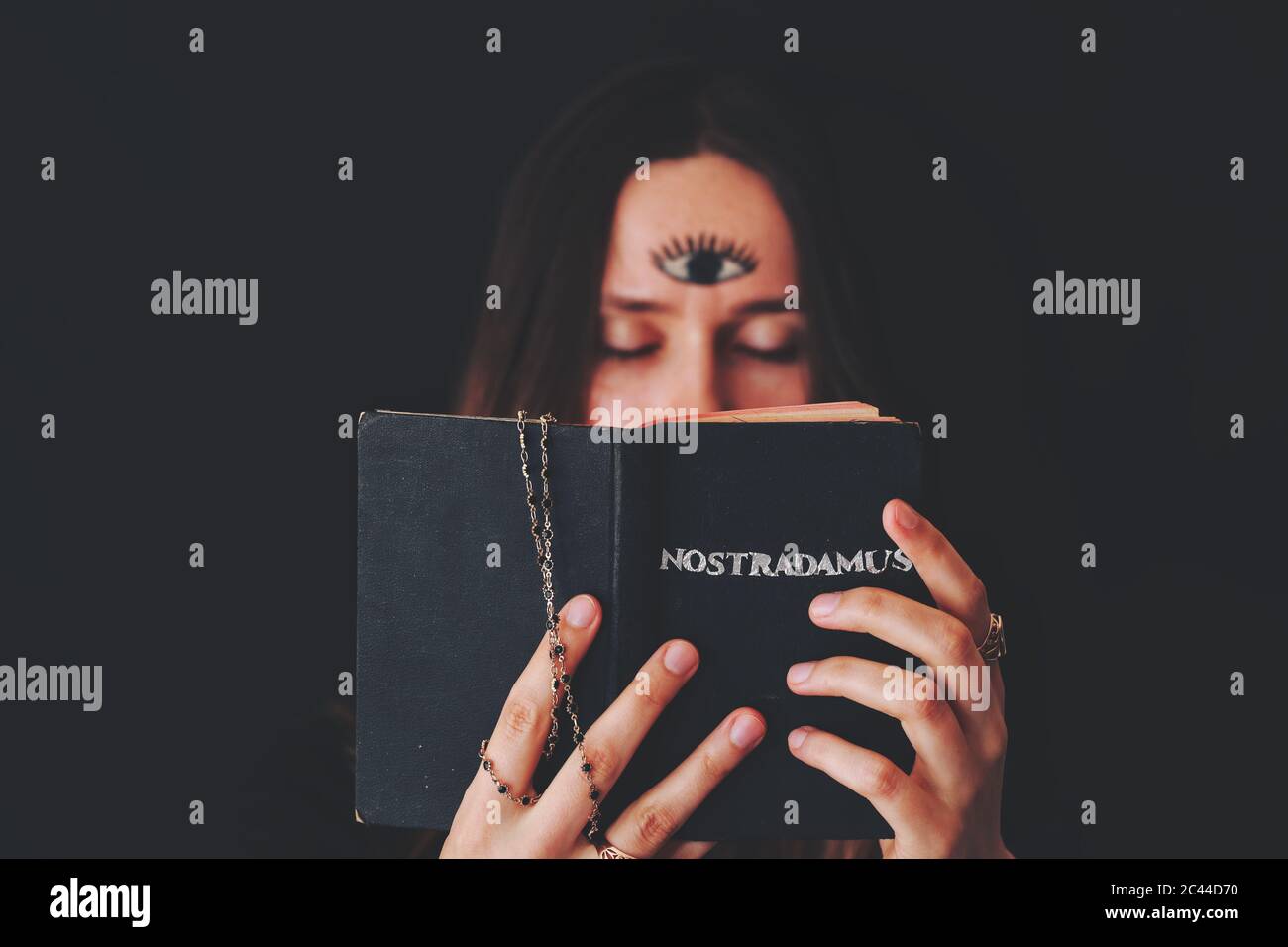 Young wiccan witch woman holding a "Nostradamus" prophecies hand made ...