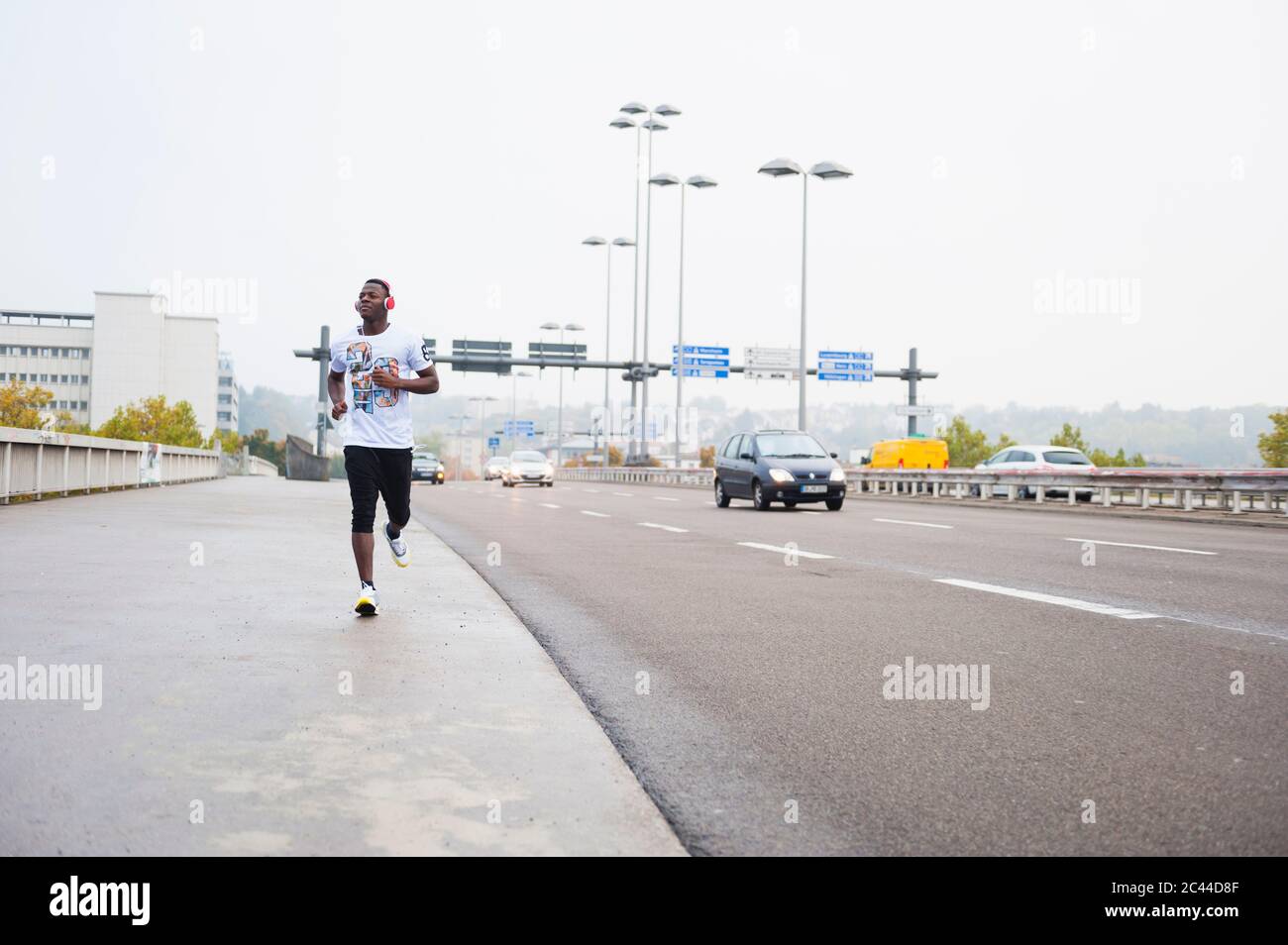 Young man jogging at street in the city Stock Photo - Alamy