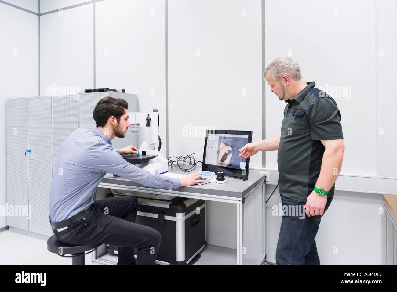 Two men working at desk in a factory Stock Photo - Alamy