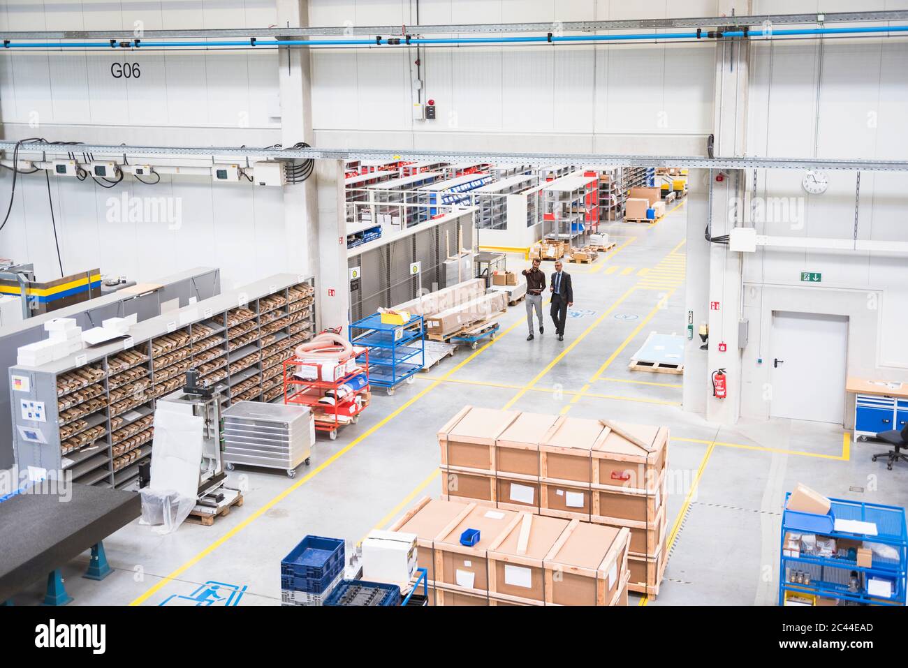 Two businessmen walking on factory shop floor Stock Photo - Alamy