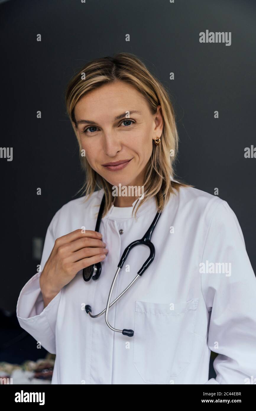 Portrait of doctor with stethoscope against grey background Stock Photo ...
