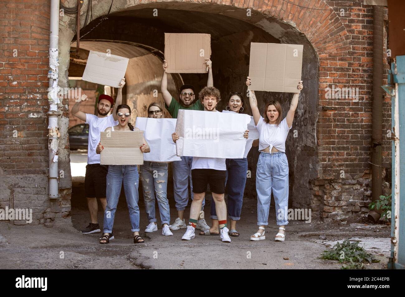 Diverse group of people protesting with blank sign. Protest against ...